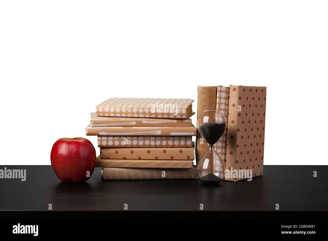 Stack of books and apple on tabletop against white background Stock ...