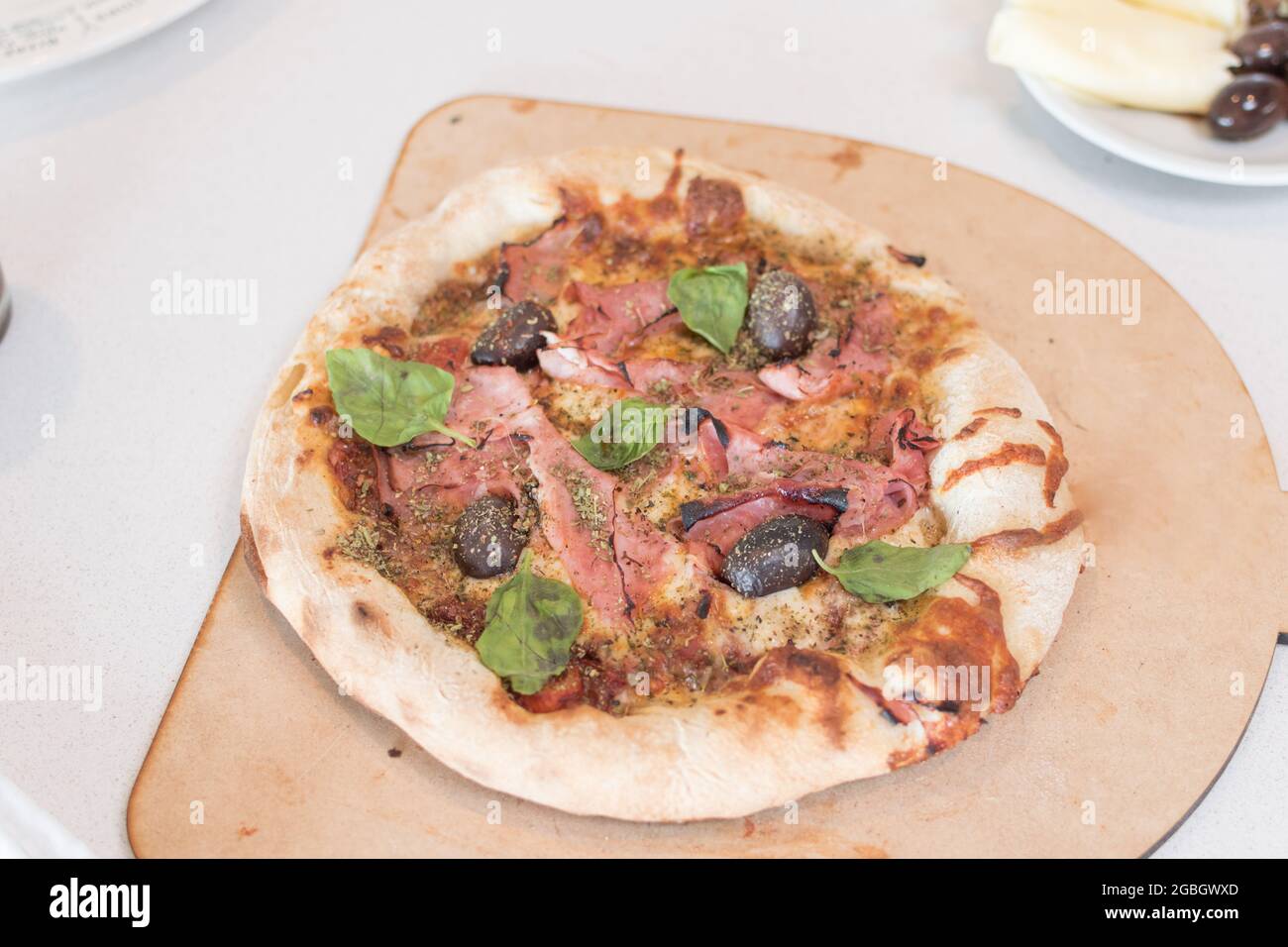 Closeup shot of small homemade round pizza served on a wooden board ...