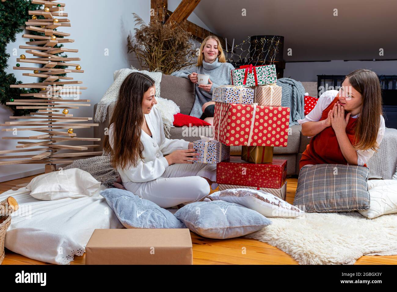 young girls having fun wrapping gifts at home, great teamwork of ...