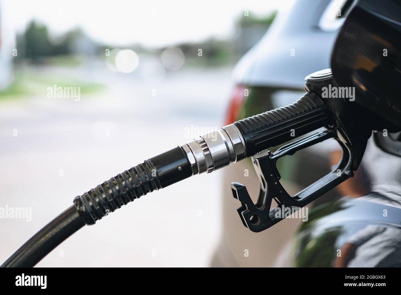 Pumping gasoline fuel in brown car at gas station Stock Photo - Alamy