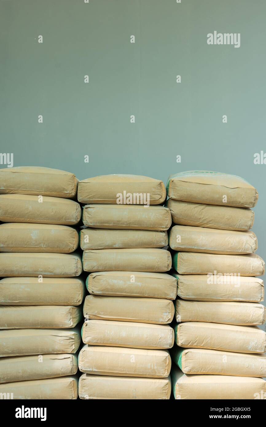 Pile of Cement in brown bags in a construction site with gray wall ...