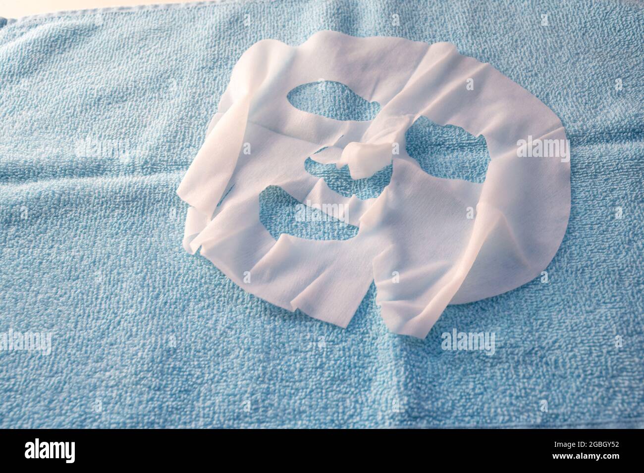 High angle shot of a face moisturizing mask on a blue towel Stock Photo ...