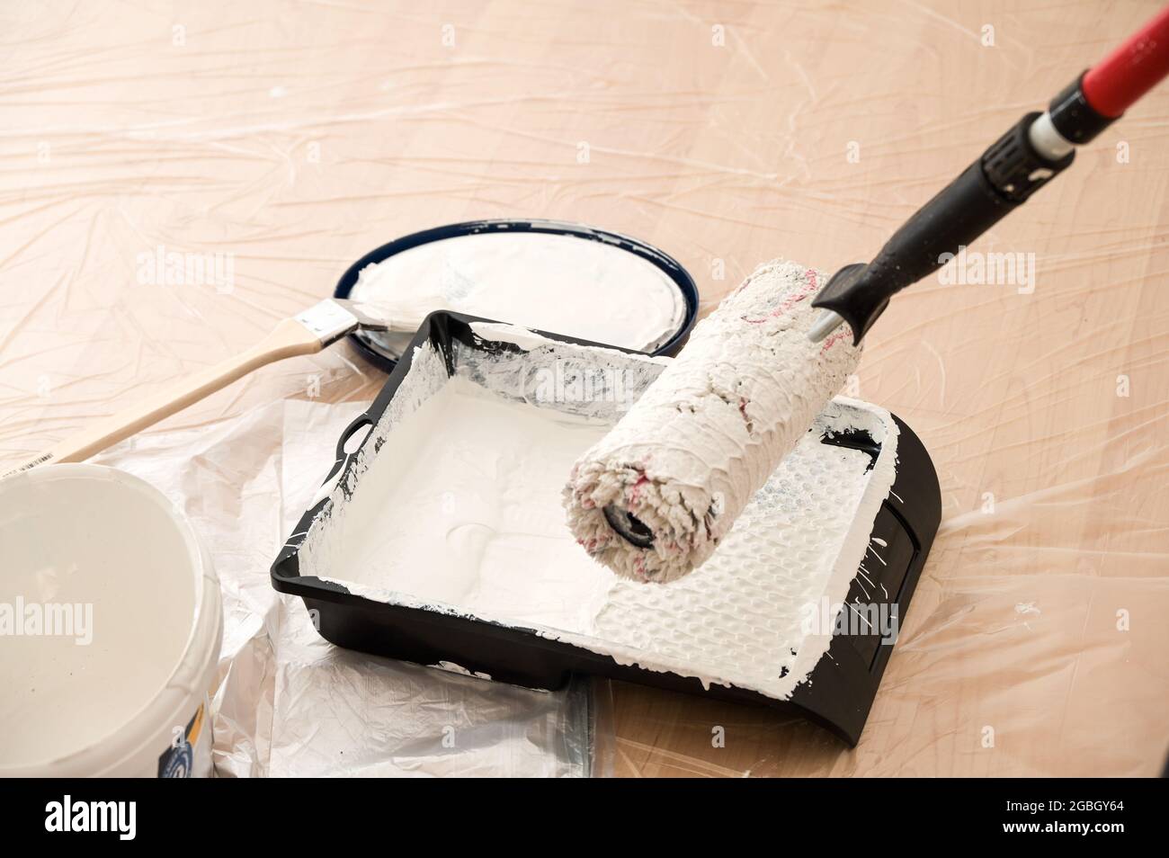 High angle shot of white paint in a bucket with special brushes and ...