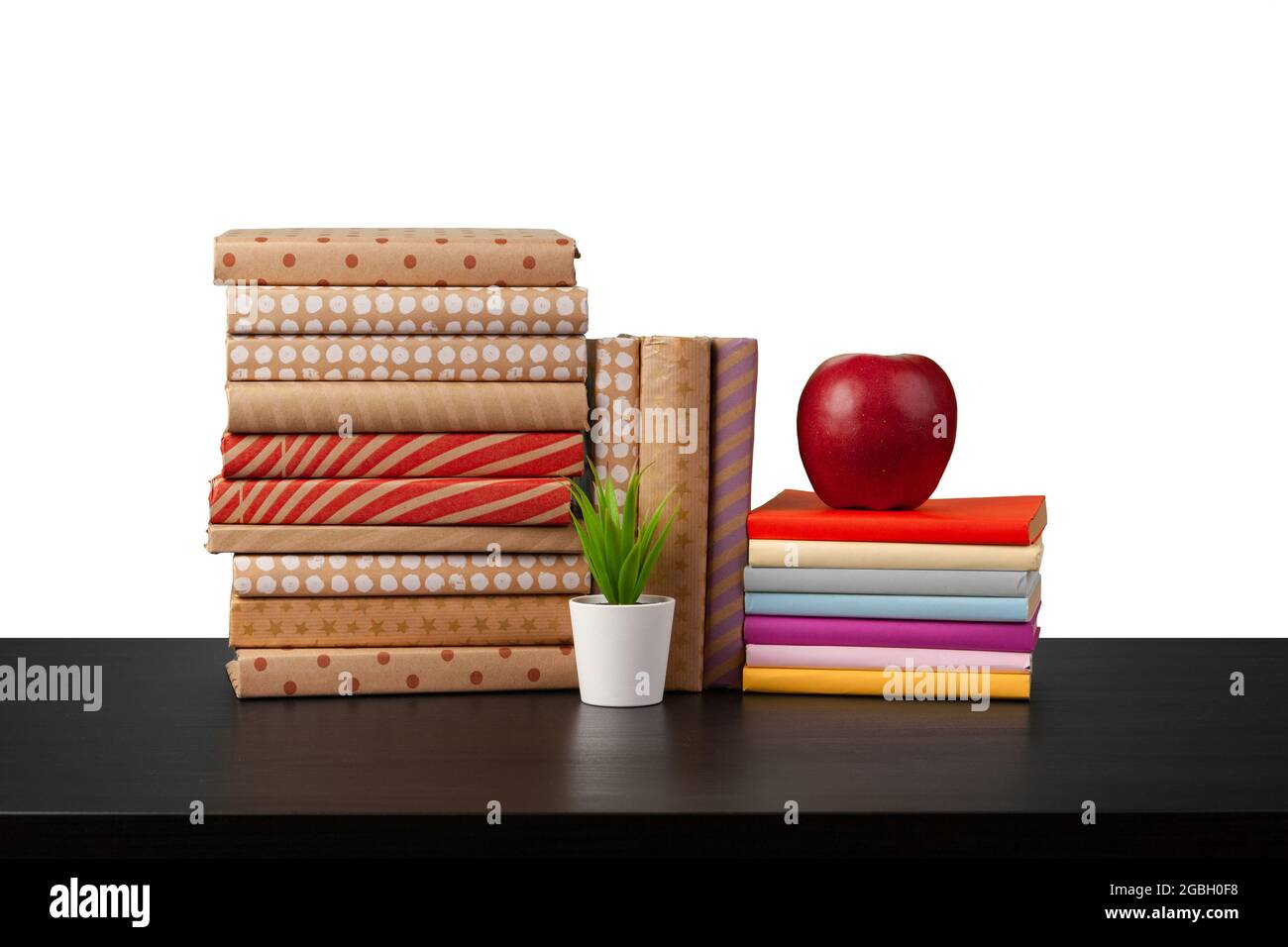 Stack of books and apple on tabletop against white background Stock ...