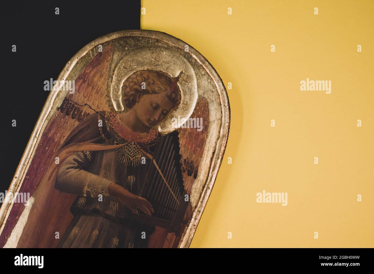 Angel ornament playing a string instrument on a black and yellow ...