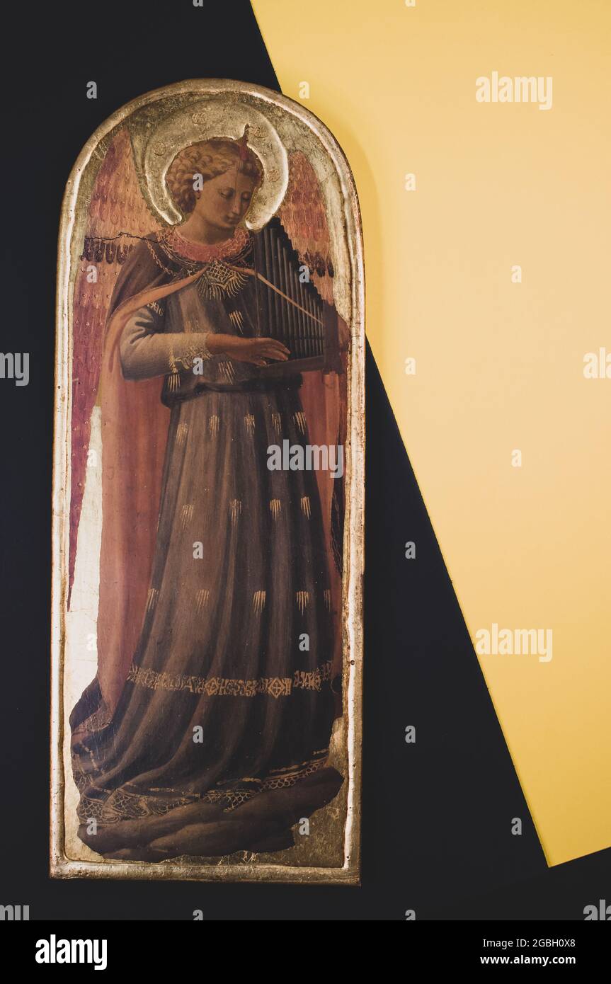 Angel ornament playing a string instrument on a black and yellow ...