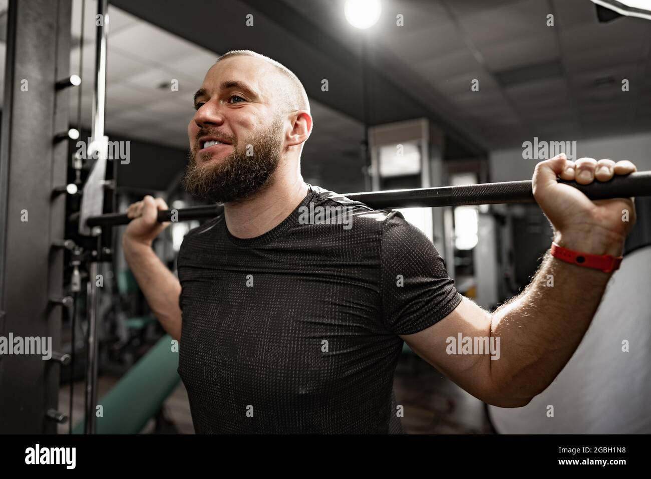 Cheerful smiling man bodybuilder standing in a gym Stock Photo - Alamy