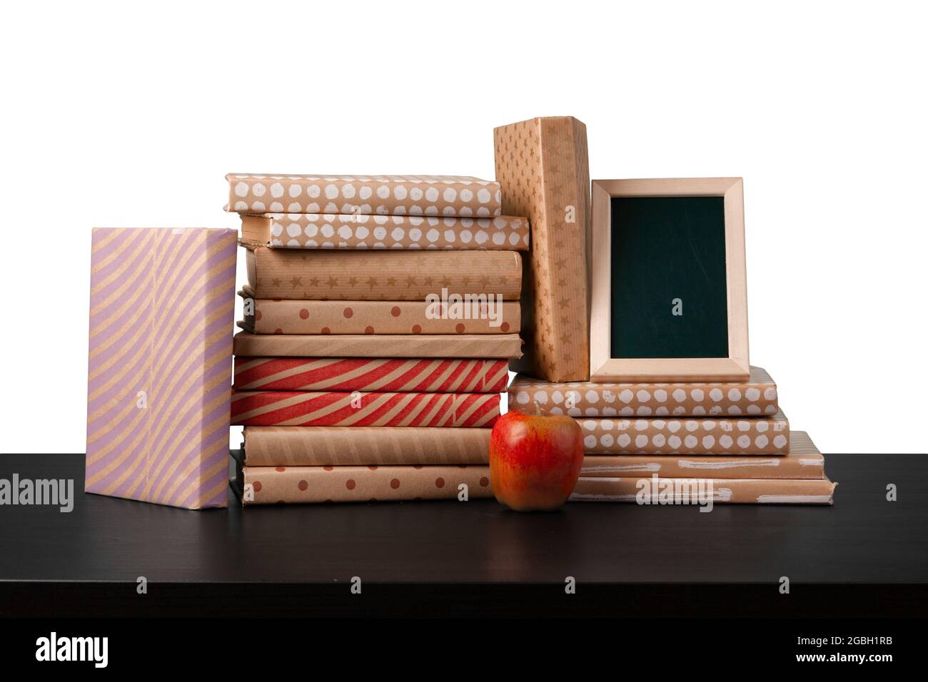 Stack of books and apple on tabletop against white background Stock ...