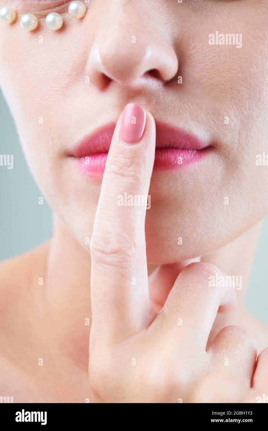 Women touching finger to lips hi-res stock photography and images - Alamy