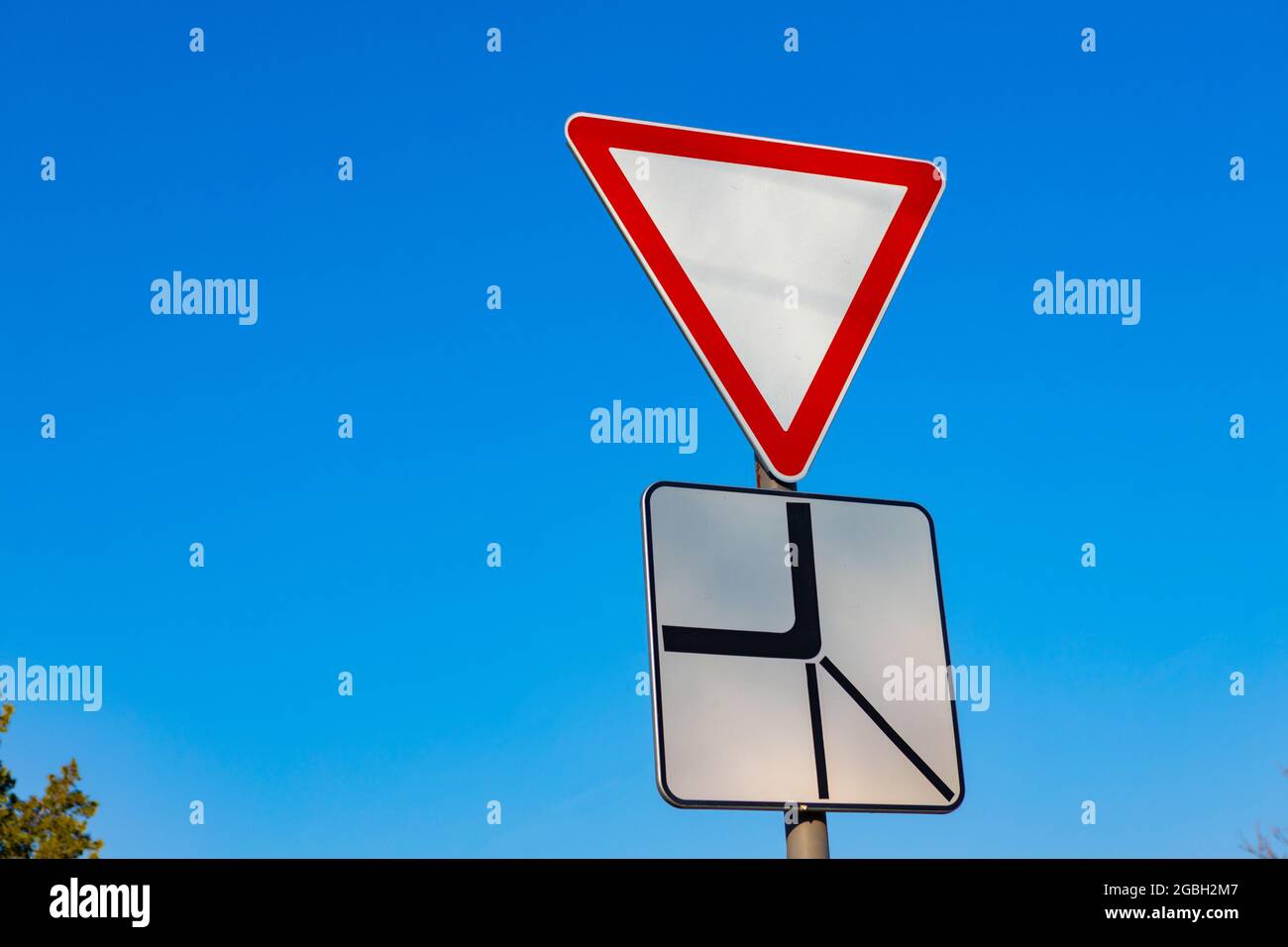 Give way traffic sign agaisnt blue sky Stock Photo - Alamy