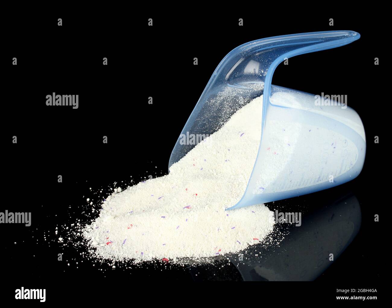 washing powder in a measuring cup, isolated on black Stock Photo - Alamy