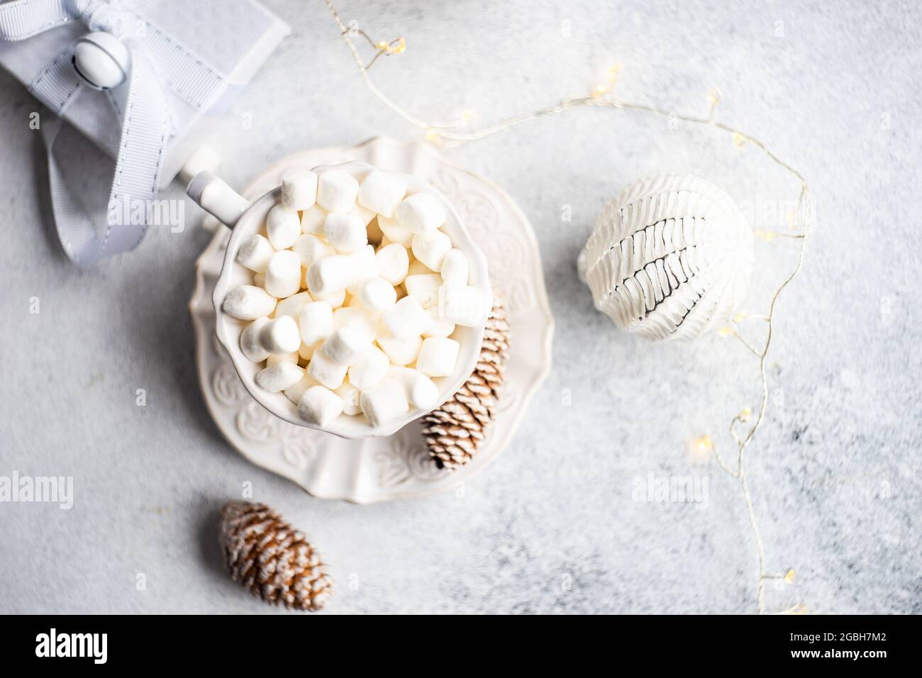 Overhead view of a cup of miniature marshmallows next to a Christmas ...