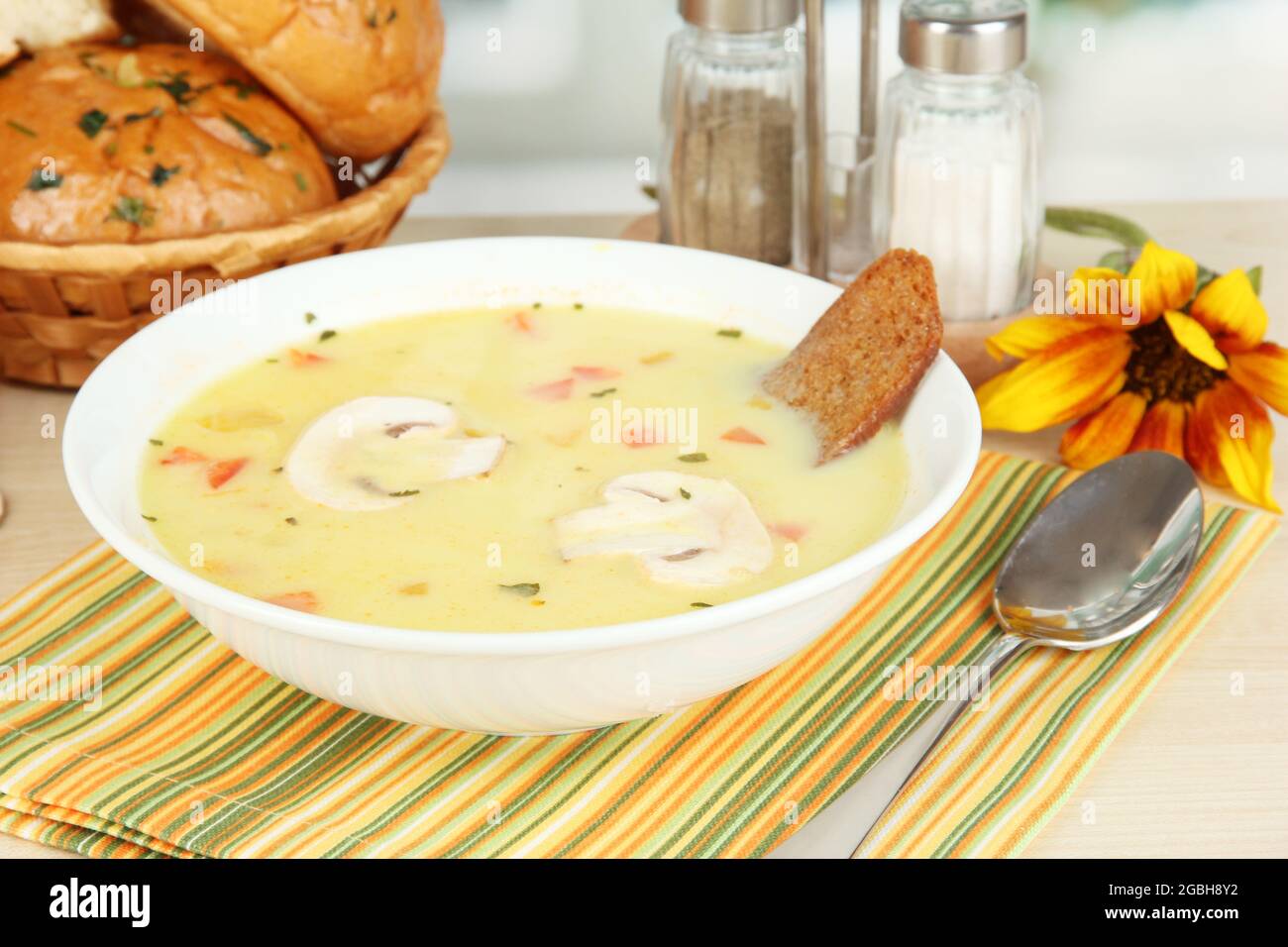 Fragrant soup in white plate on table on window background close-up ...