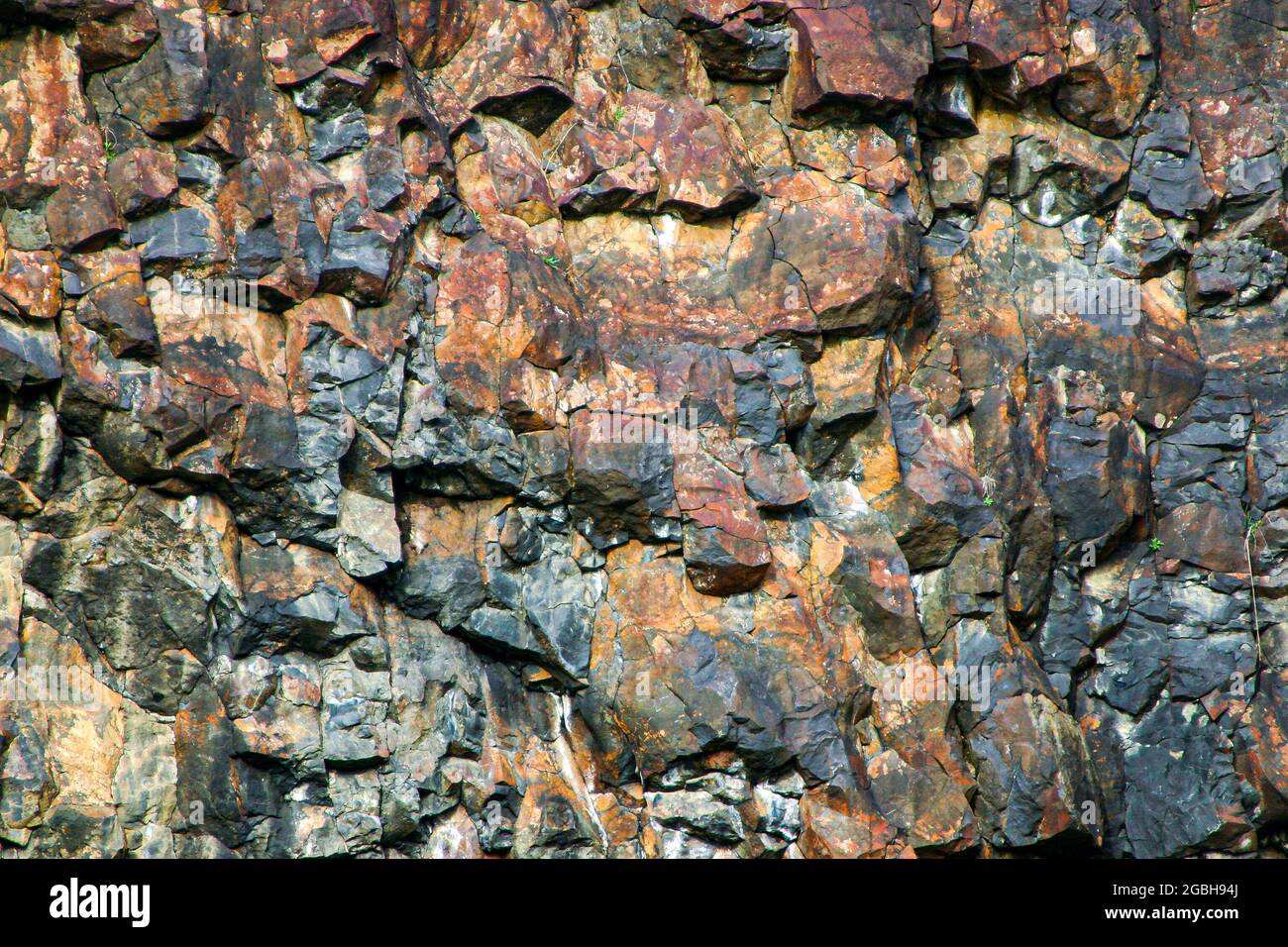 Black and brown rocky cliff face texture 02 Stock Photo - Alamy