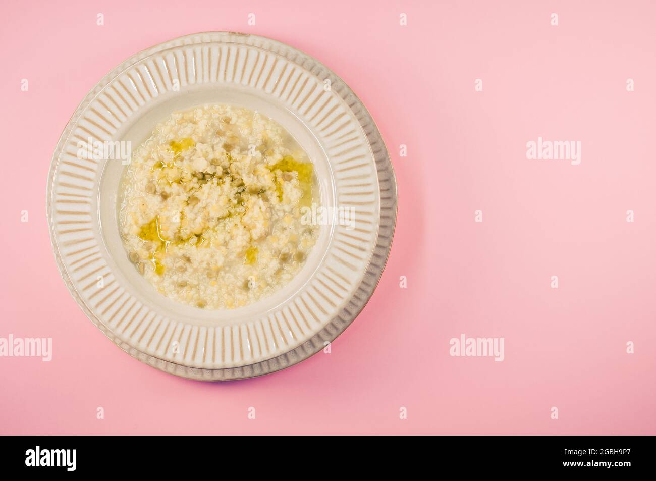 Plate of delicious porridge with corn and melted butter isolated on a ...