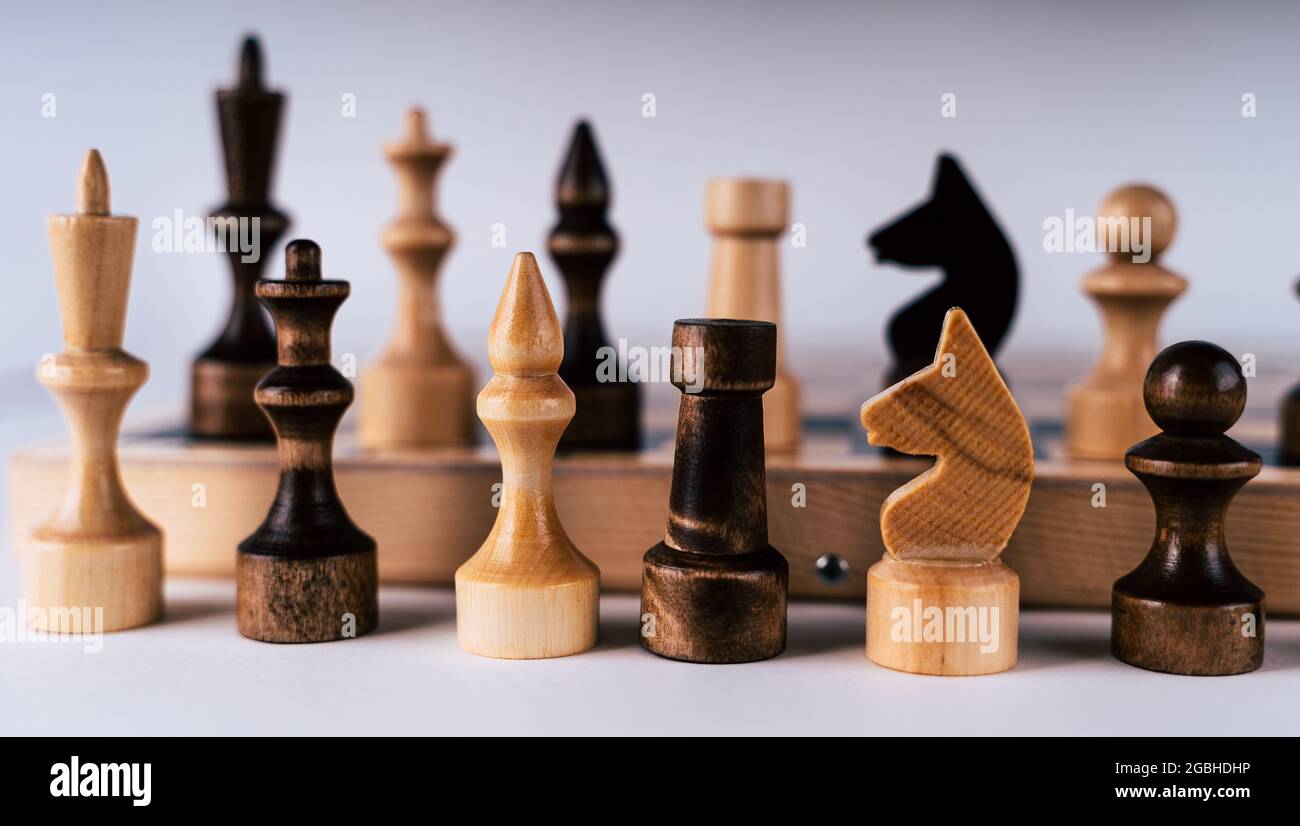 White and black wooden pieces on a chessboard. A chessboard set up ...