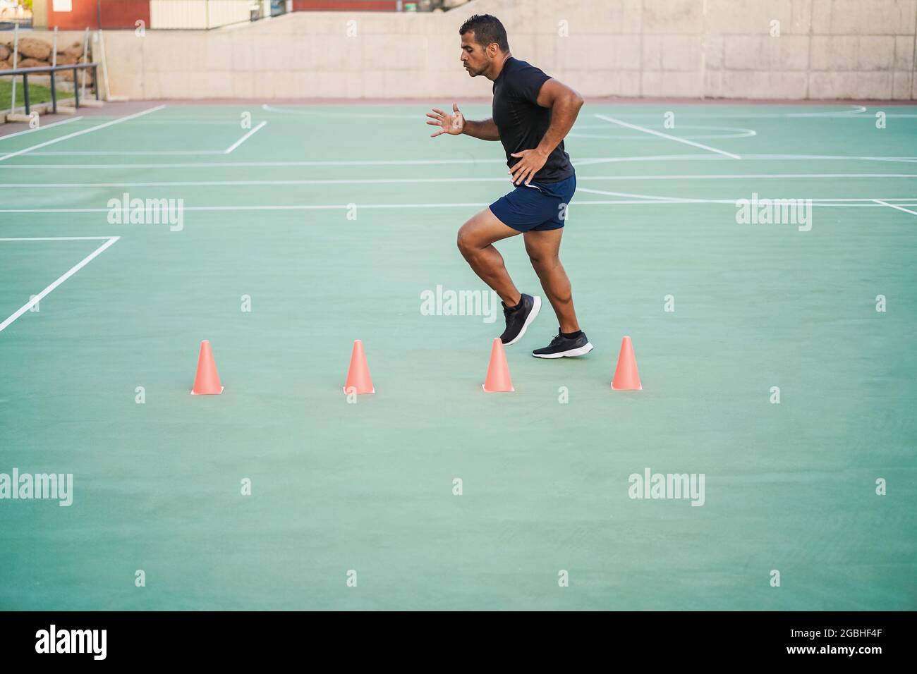 Hispanic man doing speed and agility cone drills workout session ...