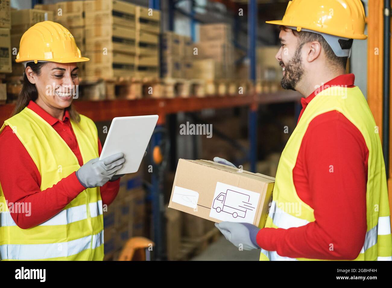 Happy workers talking while doing stock inventory inside warehouse ...