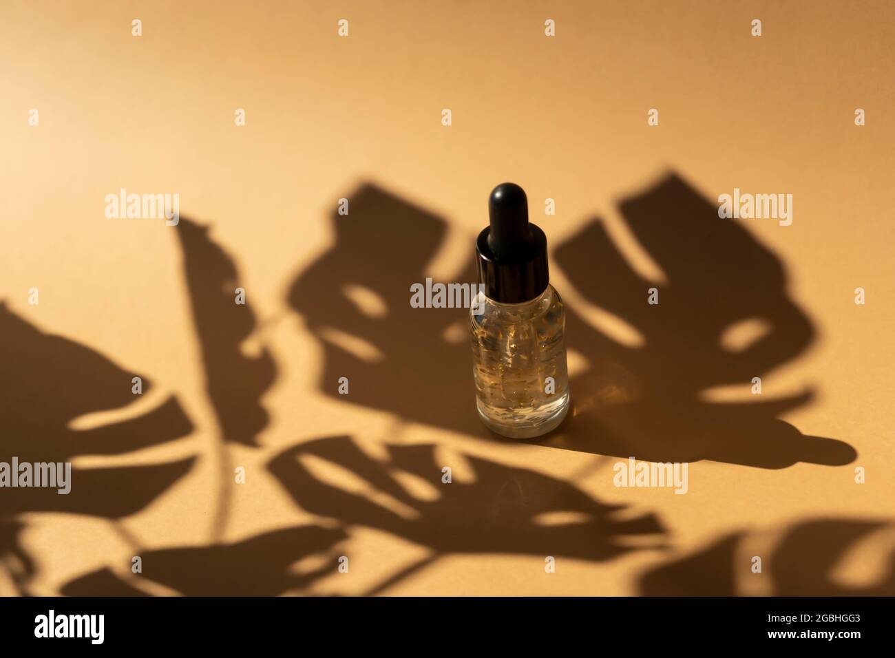 A dropper bottle of transparent essential oil with gold parts. Natural ...