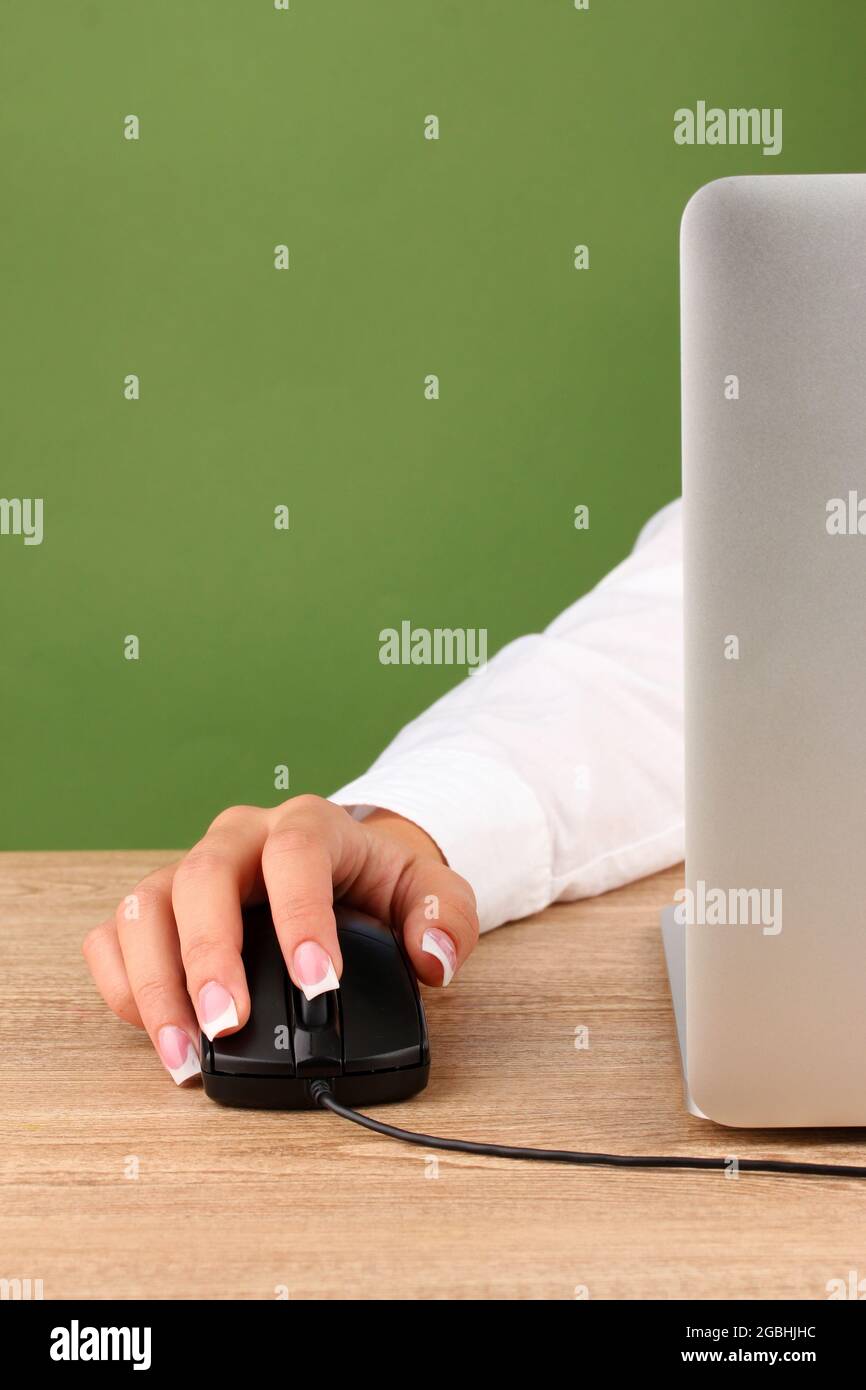 woman's hands pushing keys of pc mouse, on green background close-up ...