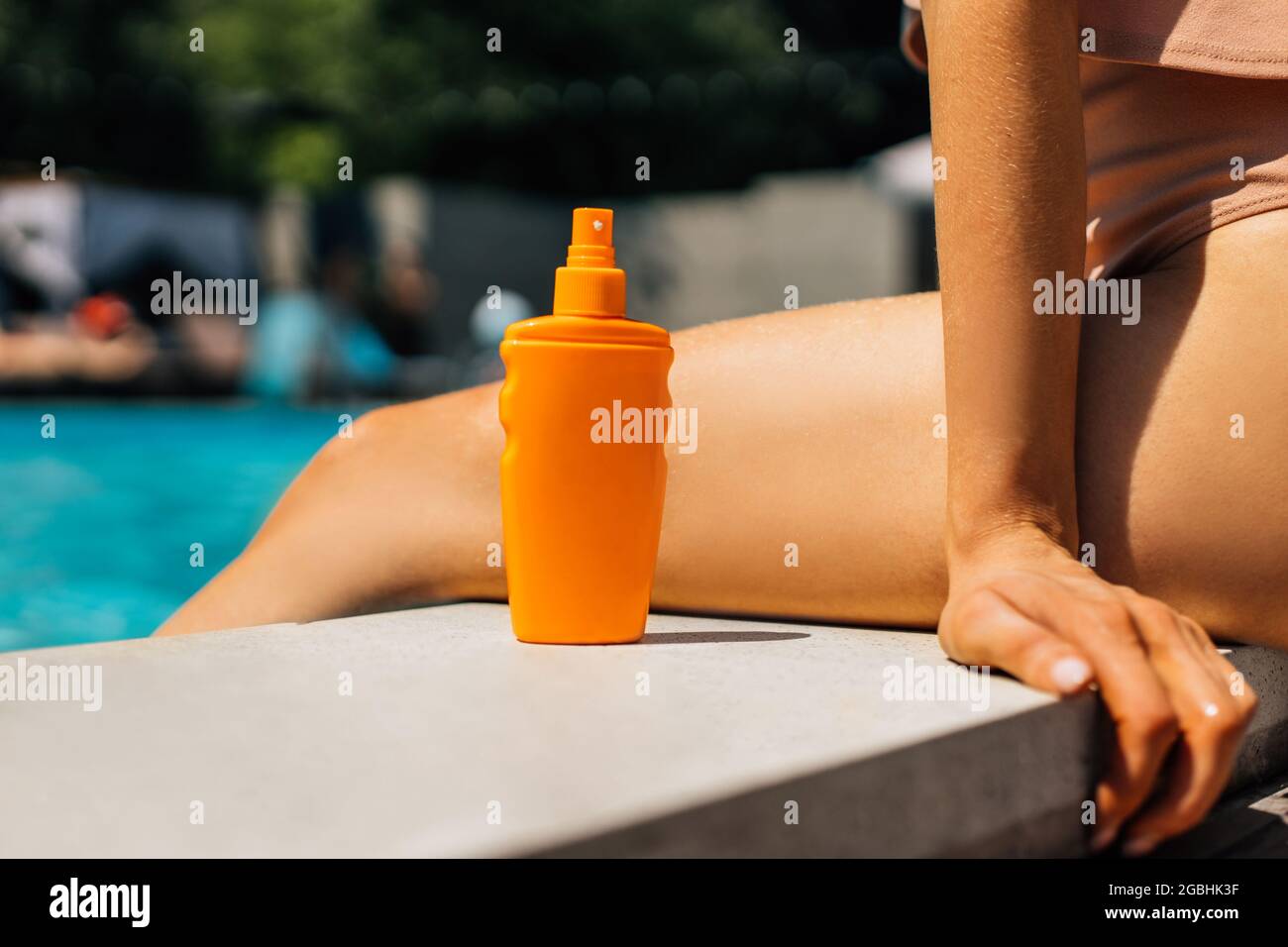 Beautiful Woman Applying Sunscreen Lotion While Sitting By The Pool