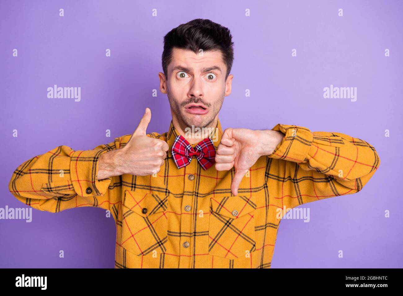 Photo of young man shocked confused show thumb up down like dislike ...