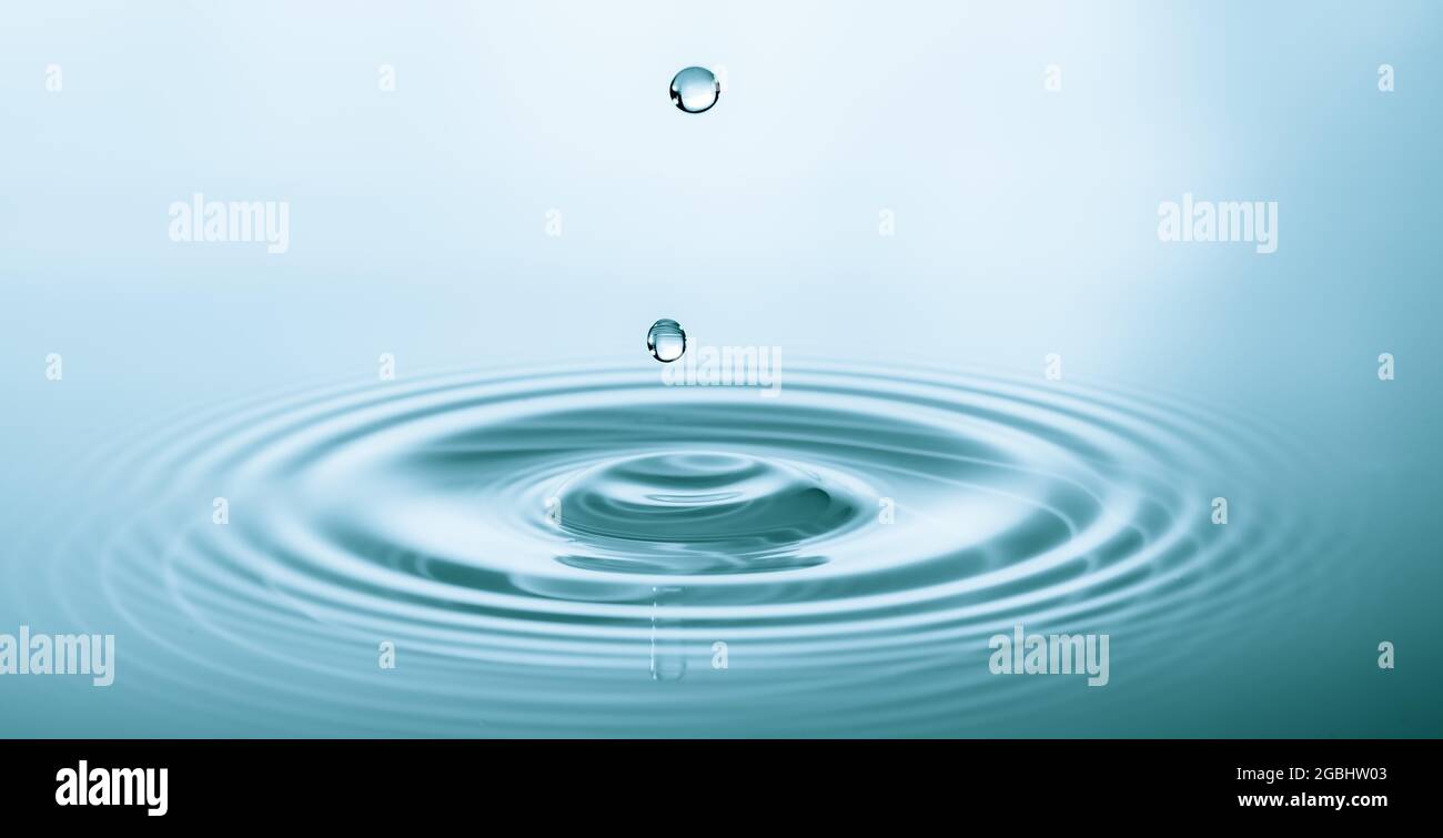 Splash of water droplets on a smooth water surface Stock Photo - Alamy