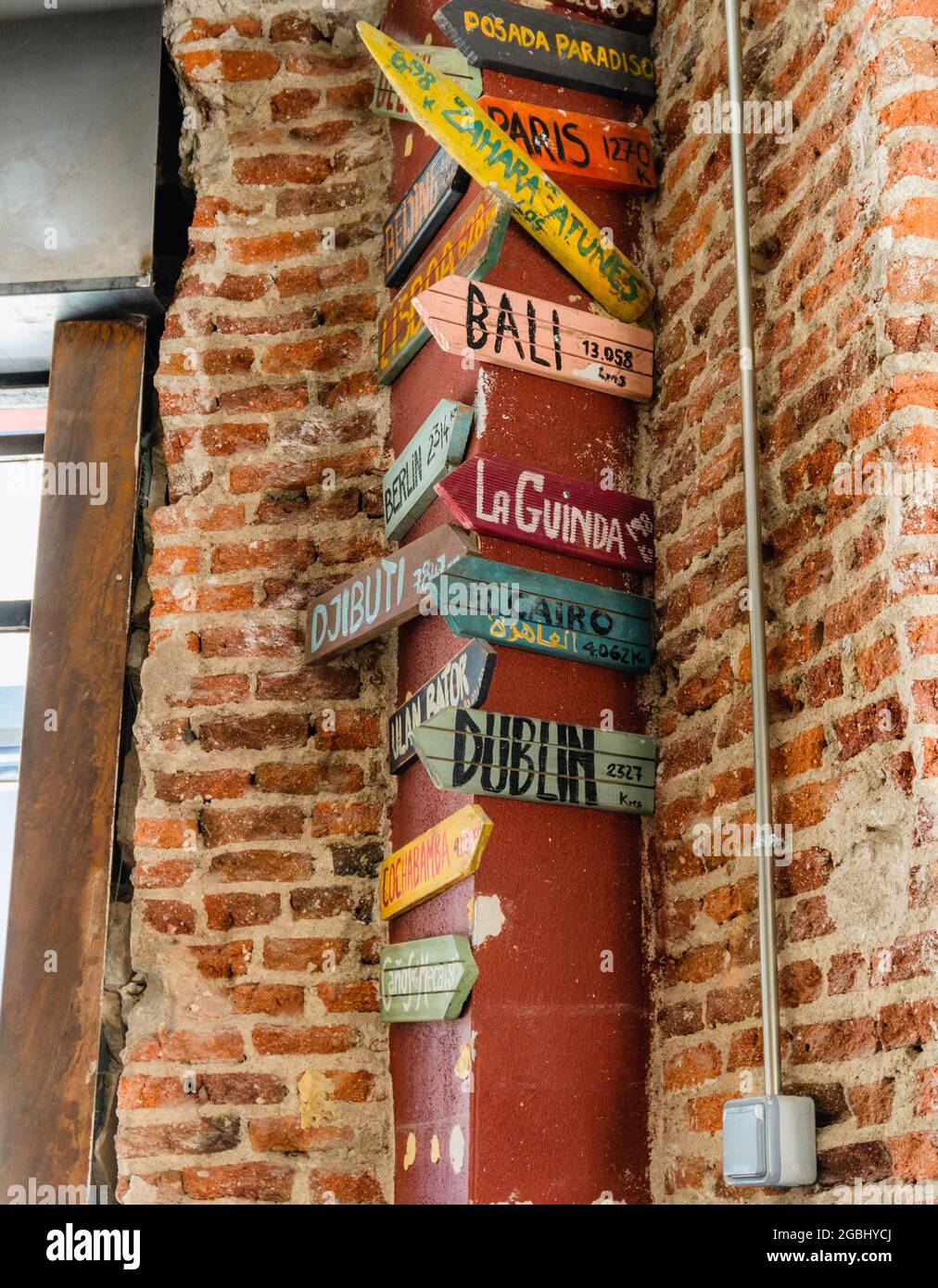 Direction wooden signpost with distance to many different cities in the ...