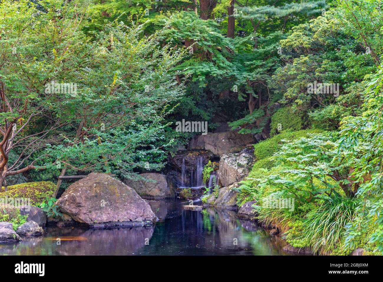 tokyo, japan - july 25 2021: Small waterfall surrounded by rocks and ...