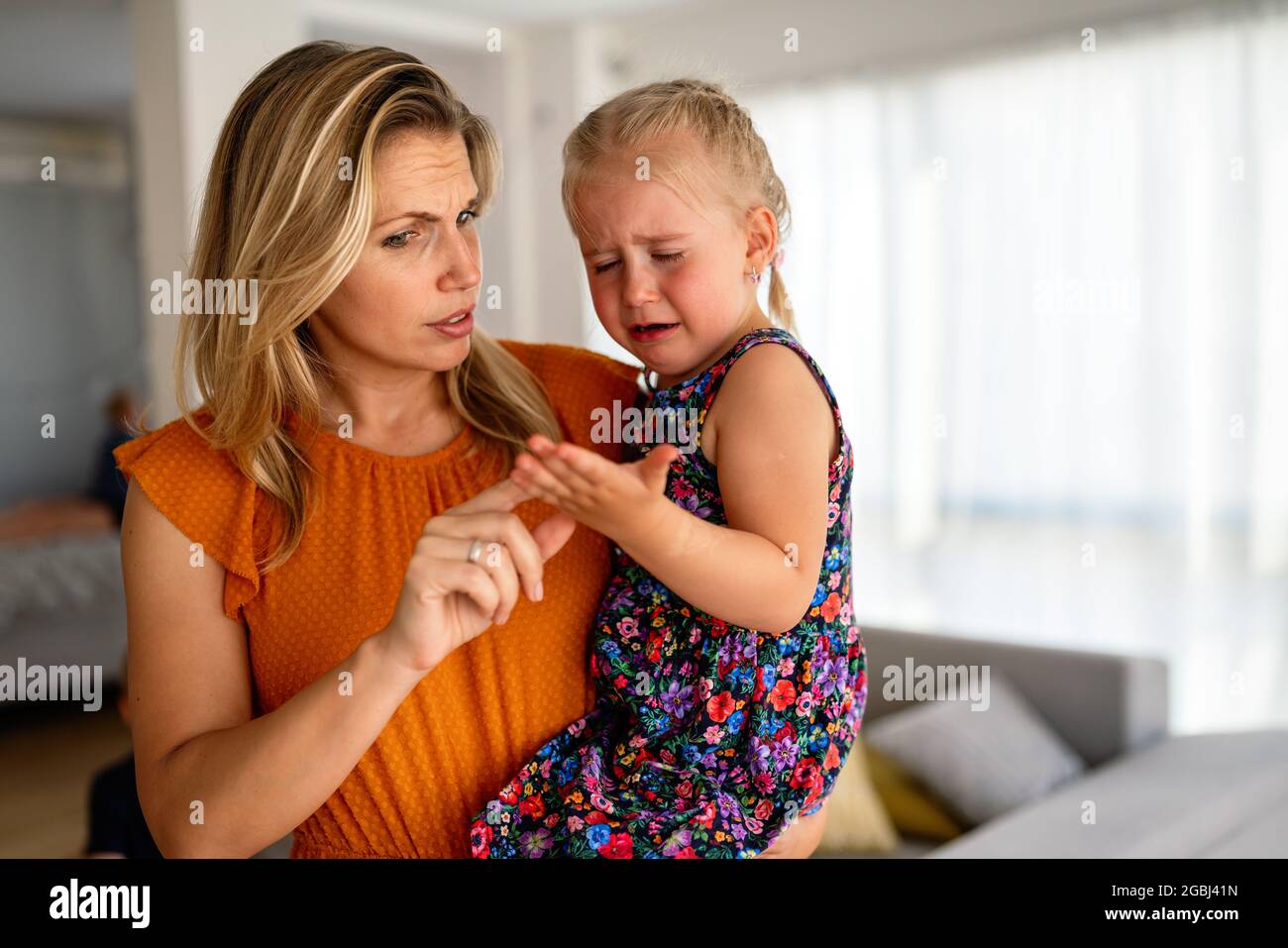 Mother comforting her crying child after she hit her hand Stock Photo ...