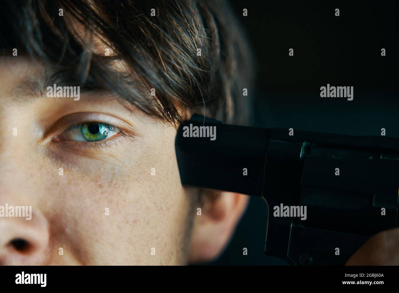 Sad man puts a gun to his temple. Despair in the eyes. Male wants to ...