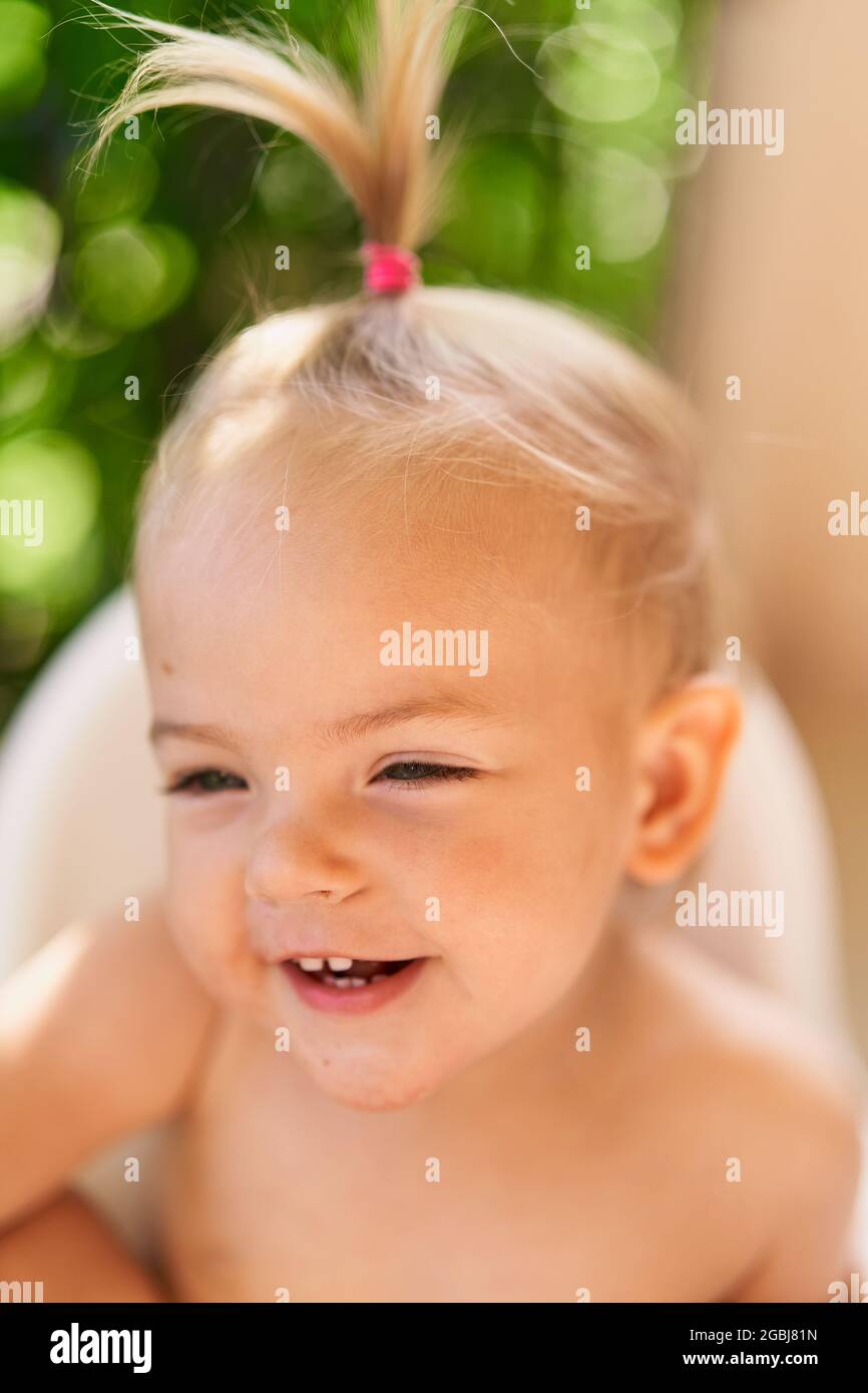 Baby girl ponytail sitting smiling hi-res stock photography and images ...