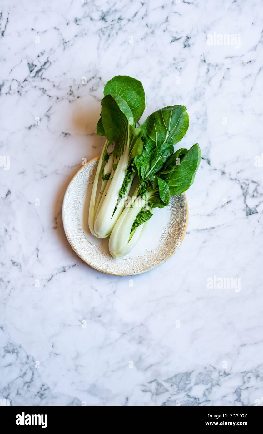Plate with Bok Choy on a marble table Stock Photo - Alamy