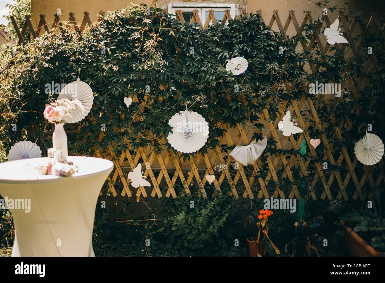 Fence decorated with plants and white butterflies for wedding ceremon ...