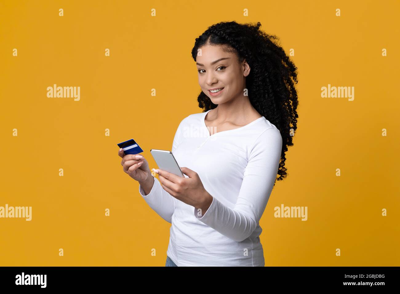 Mobile Shopping. Black lady with smartphone and credit card over yellow ...