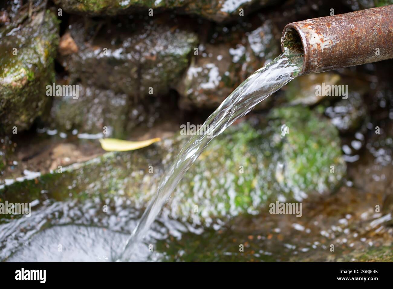 Spring water flows from a rusty pipe Stock Photo - Alamy