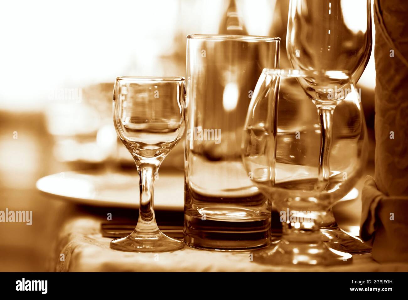 Glass goblets on the restaurant table tinted in brown Stock Photo - Alamy
