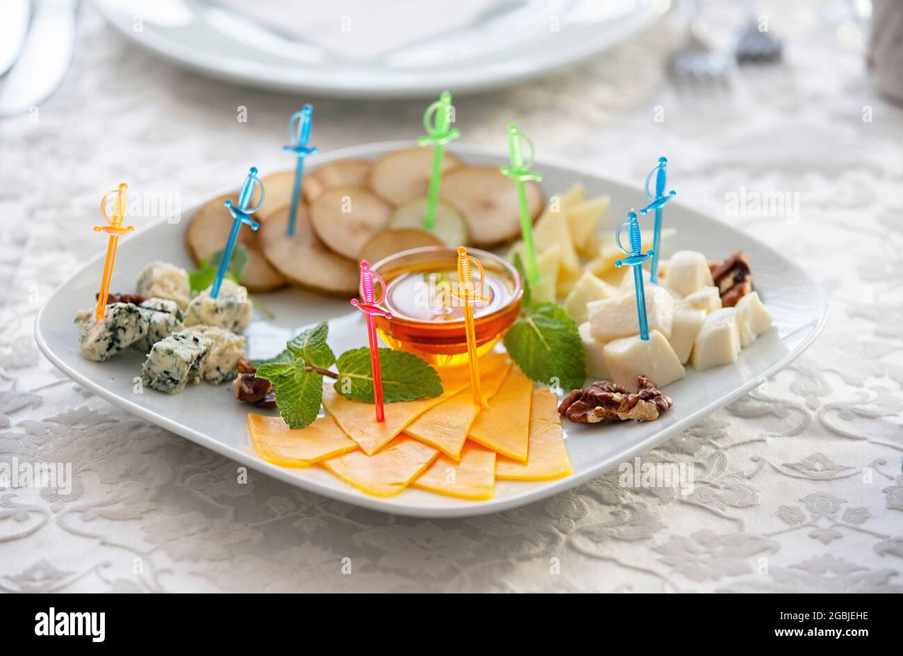 On the plate is an appetizer of sliced cheese of different varieties ...