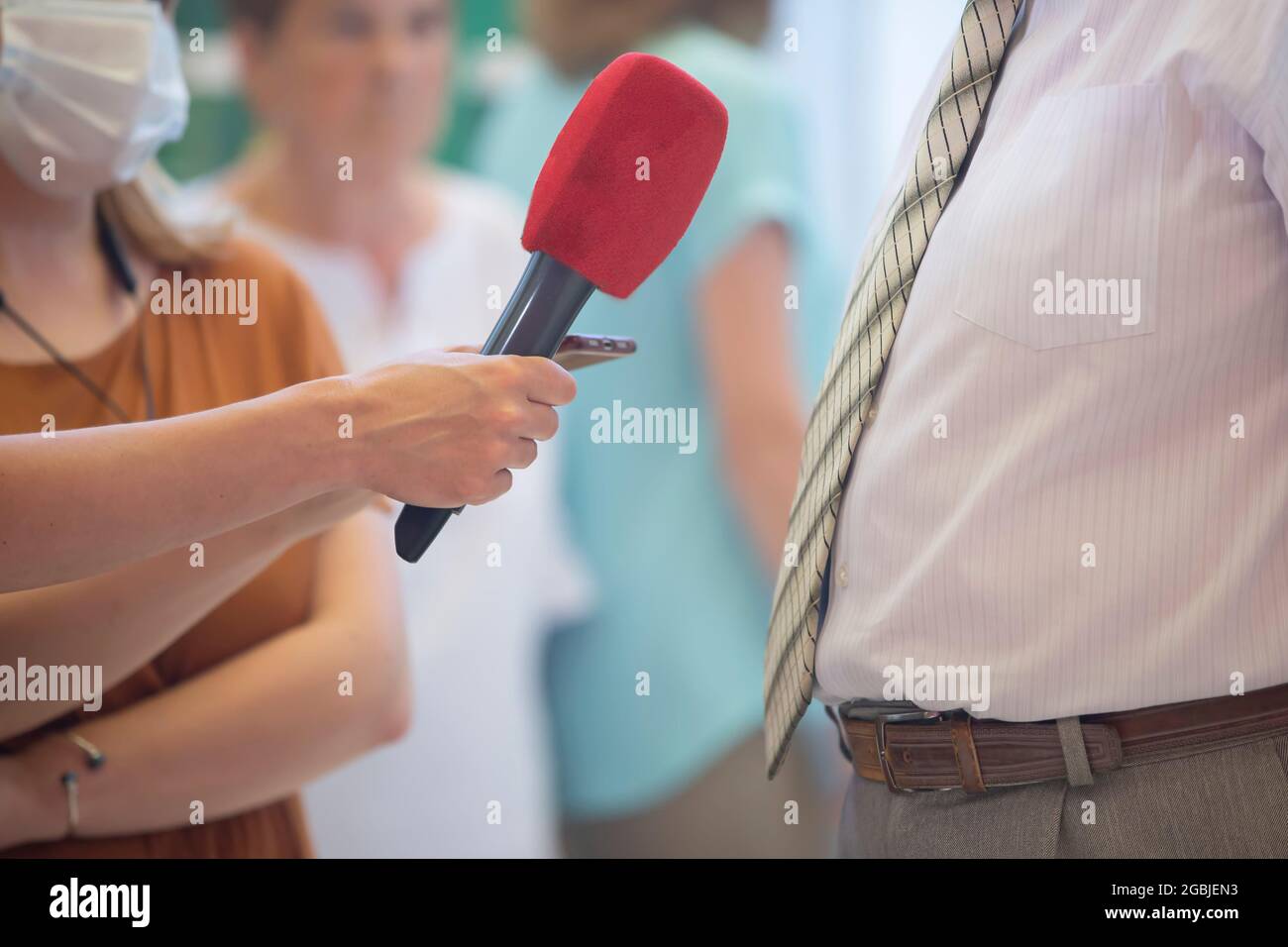 Interview. Hand with a microphone and an important gentleman in a tie ...
