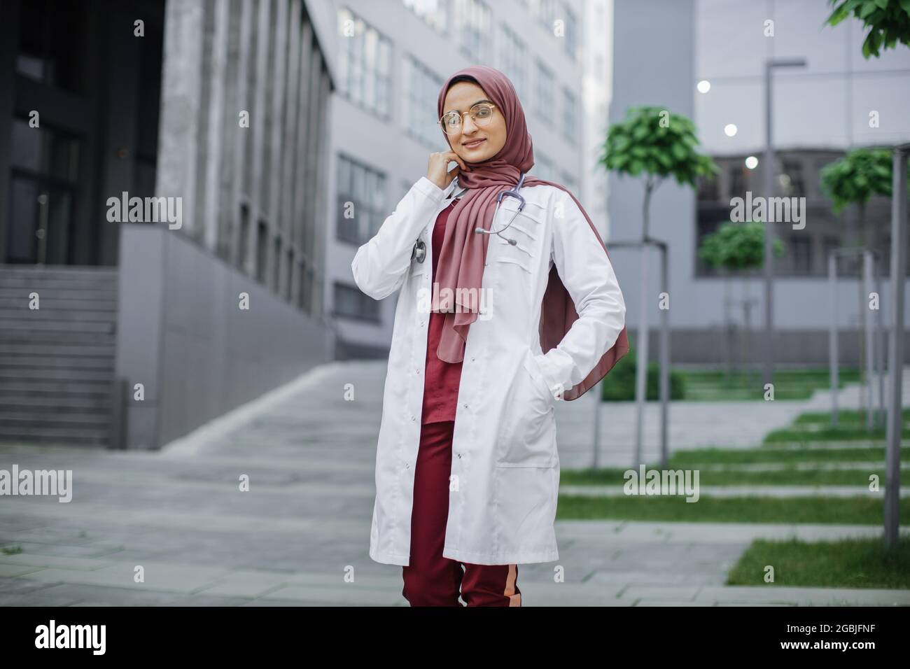 Outdoor portrait of beautiful Malay Muslim nurse with stethoscope ...