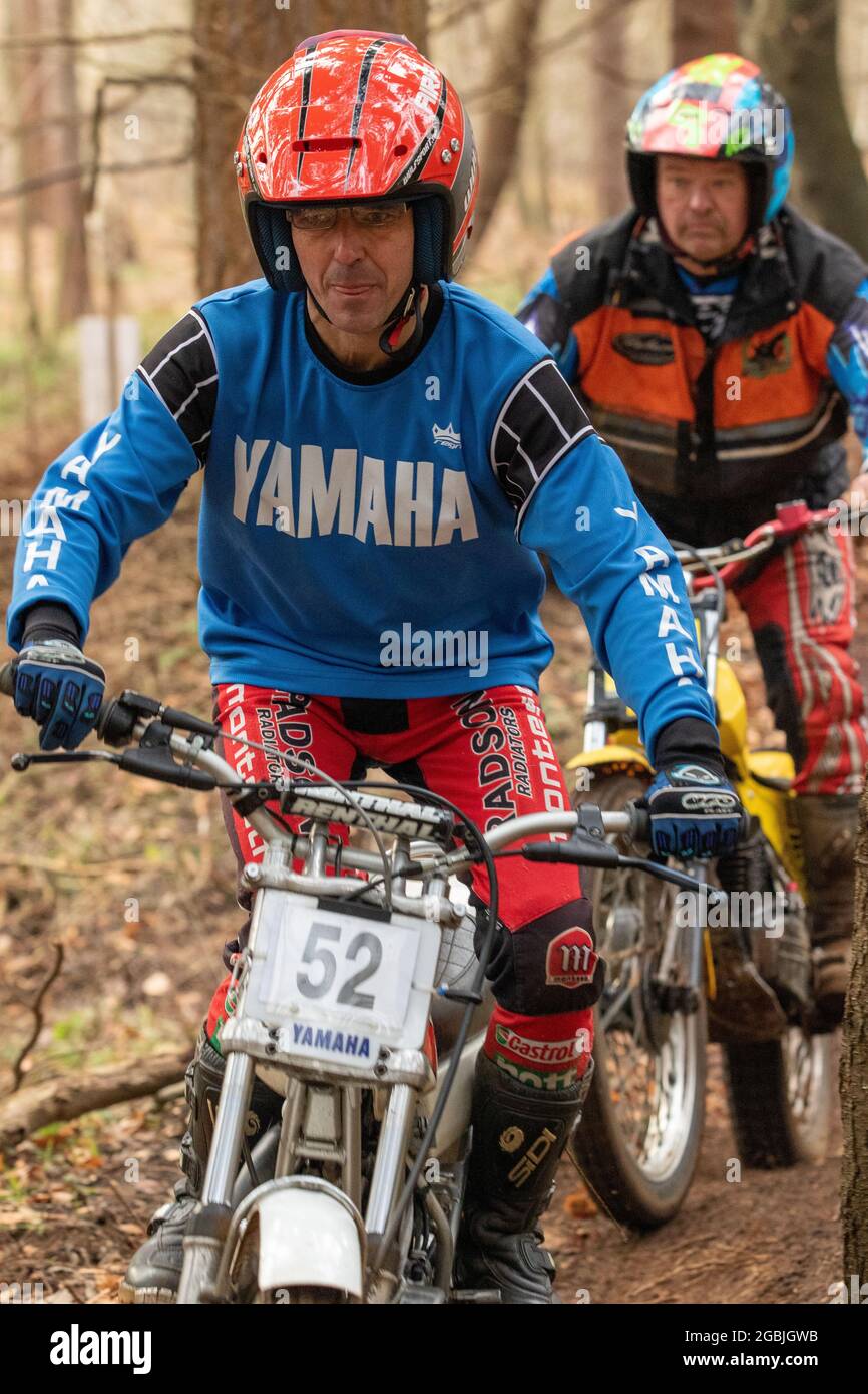 Motorcycle riders cruising through woodland between sections at a ...