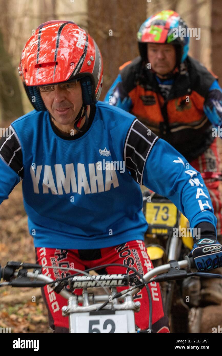 Motorcycle riders cruising through woodland between sections at a ...