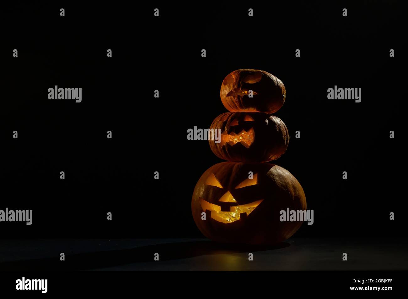 A spooky pyramid of jack-o-lantern in the dark. Glowing scary smirk ...