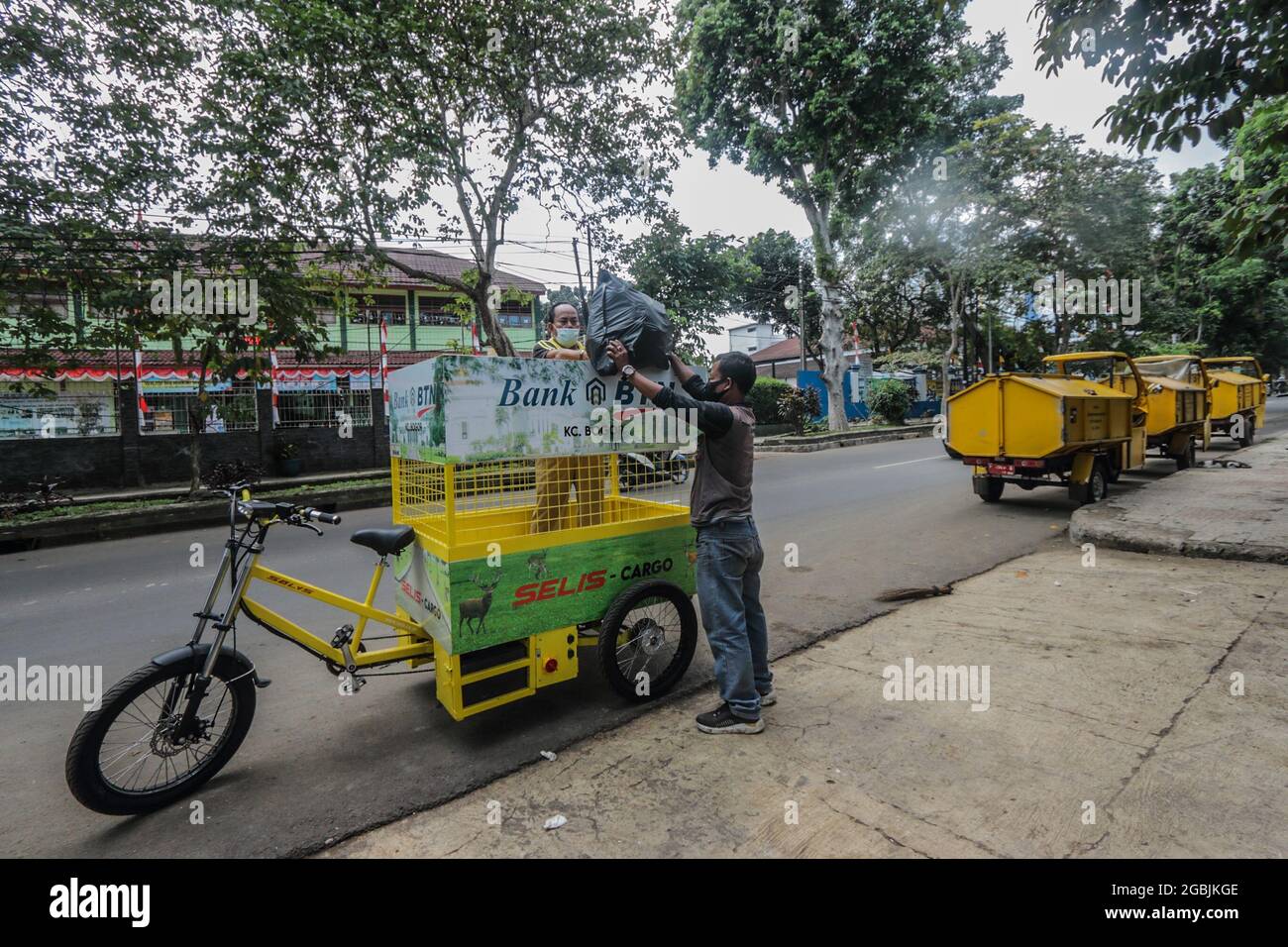 An officer is seen loading garbage into an electric bicycle that ...