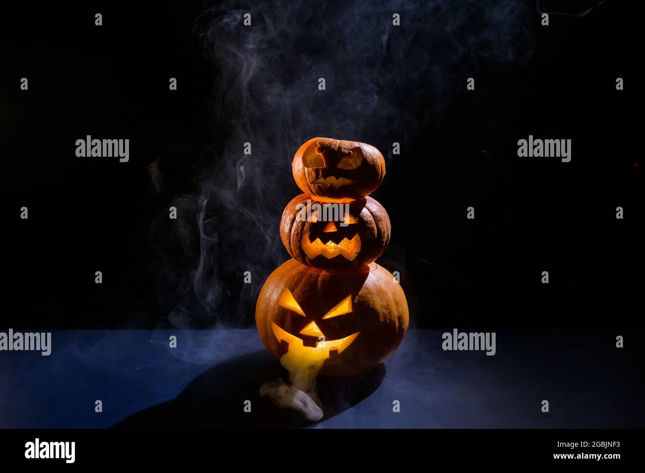 A spooky pyramid of jack-o-lantern in the dark. Glowing scary smirk ...