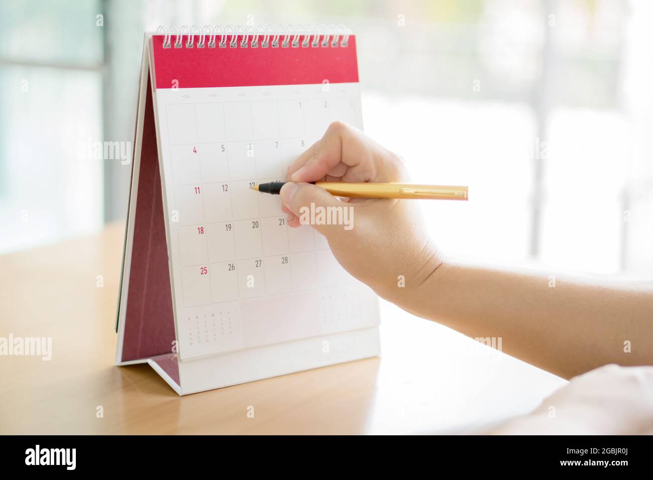 Woman hand carrying calendar and pointing on it by pen Stock Photo - Alamy