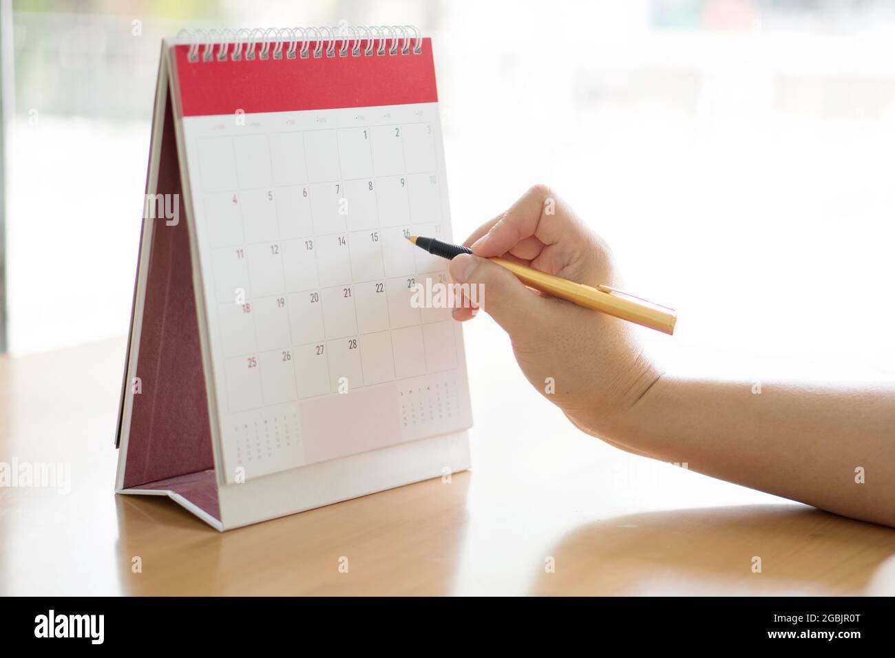 Woman hand carrying calendar and pointing on it by pen Stock Photo - Alamy