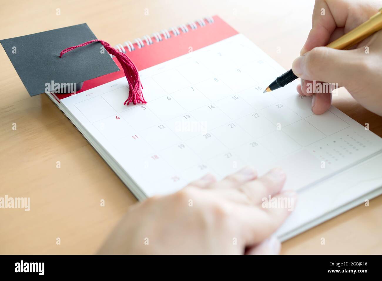 hand holding pen and marking on calendar Stock Photo - Alamy