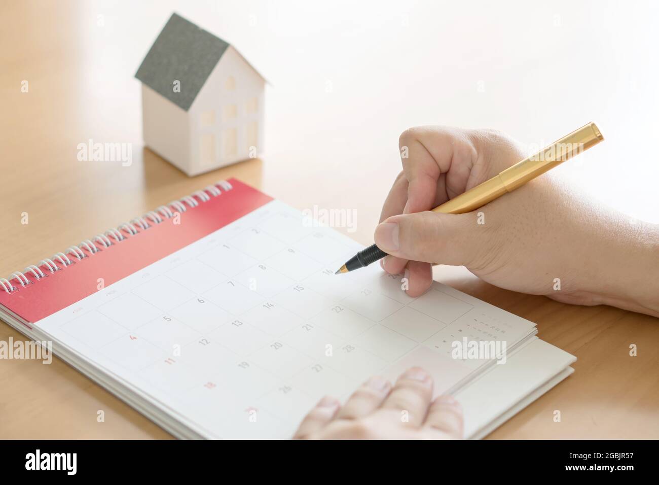 hand holding pen and marking on calendar Stock Photo - Alamy