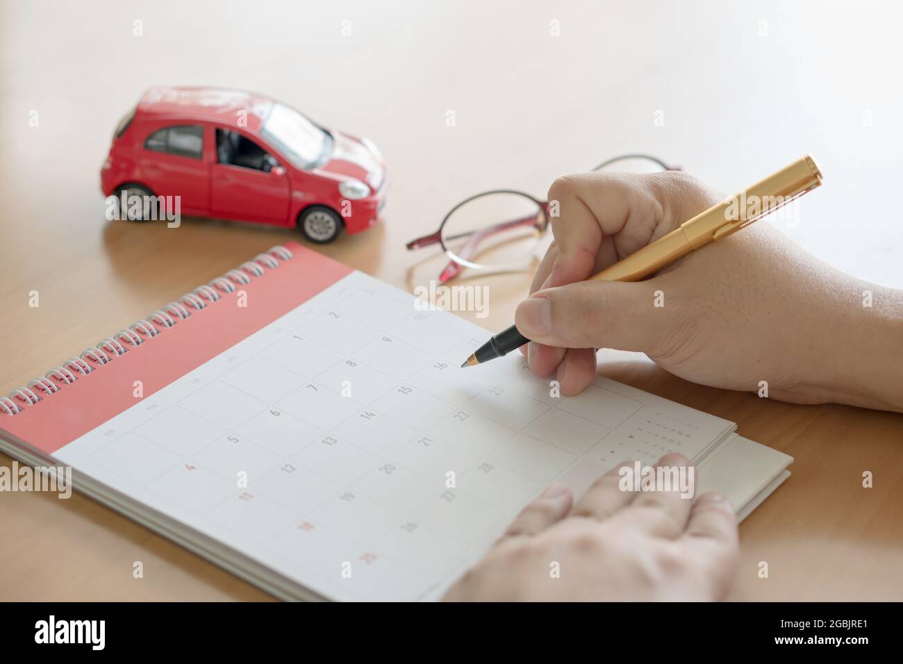 hand holding pen and marking on calendar Stock Photo - Alamy
